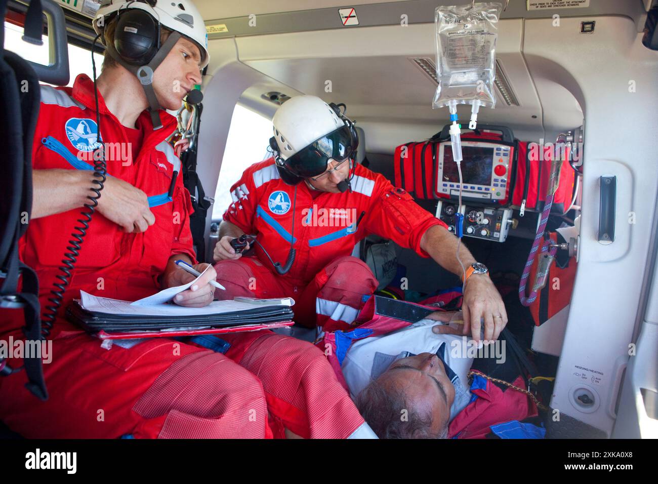 A doctor and paramedic inside a rescue helicopter. They are helping an ...
