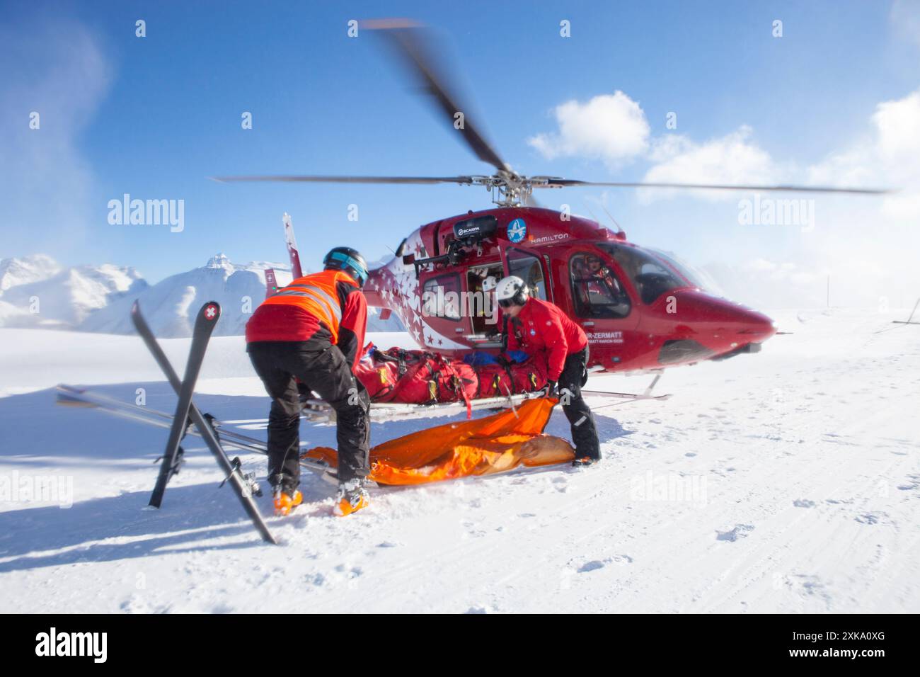 An emergency doctor and a paramedic are helping an injured skier next ...