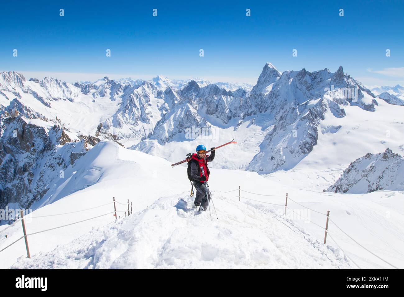 A male freerider is walking down a mountain ridge from the Aiguille du ...