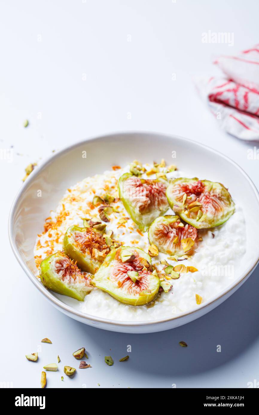 Breakfast cottage cheese with figs and maple syrup, white background ...