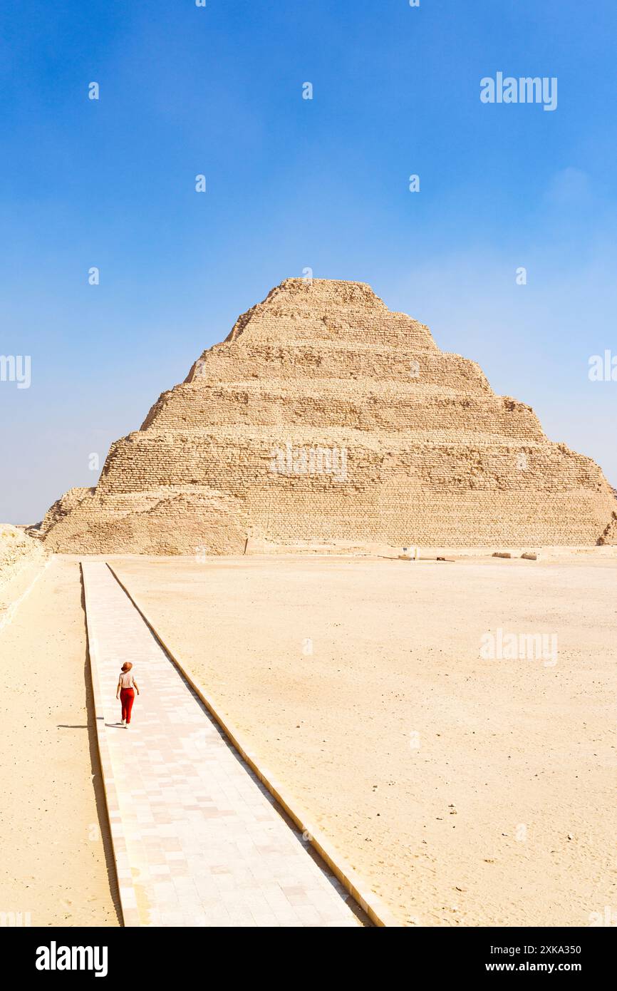 Woman with hat walking on path to the Step Pyramid of Djoser, Egypt ...