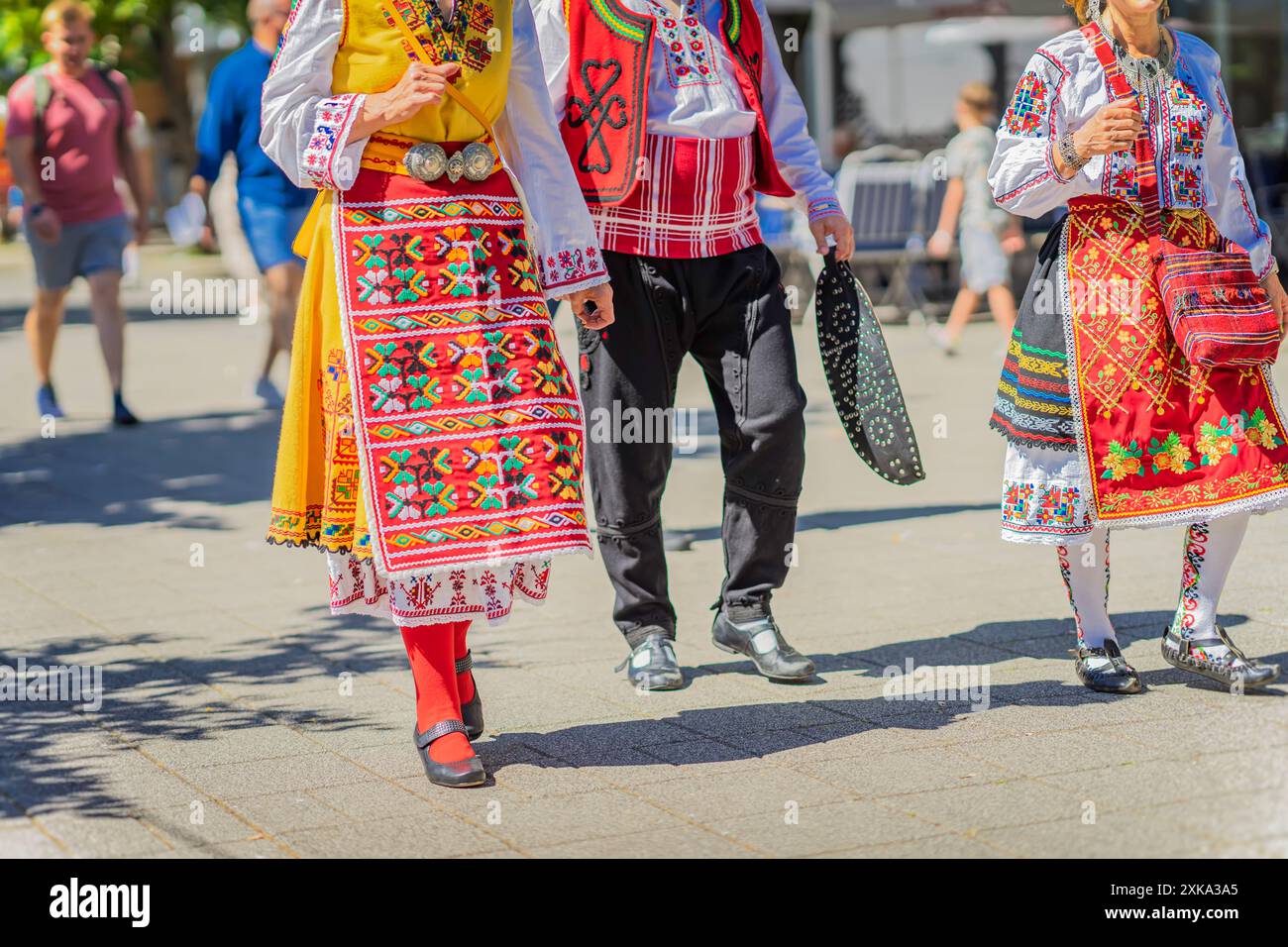 People walk down the street in traditional Bulgarian folk costumes with ...