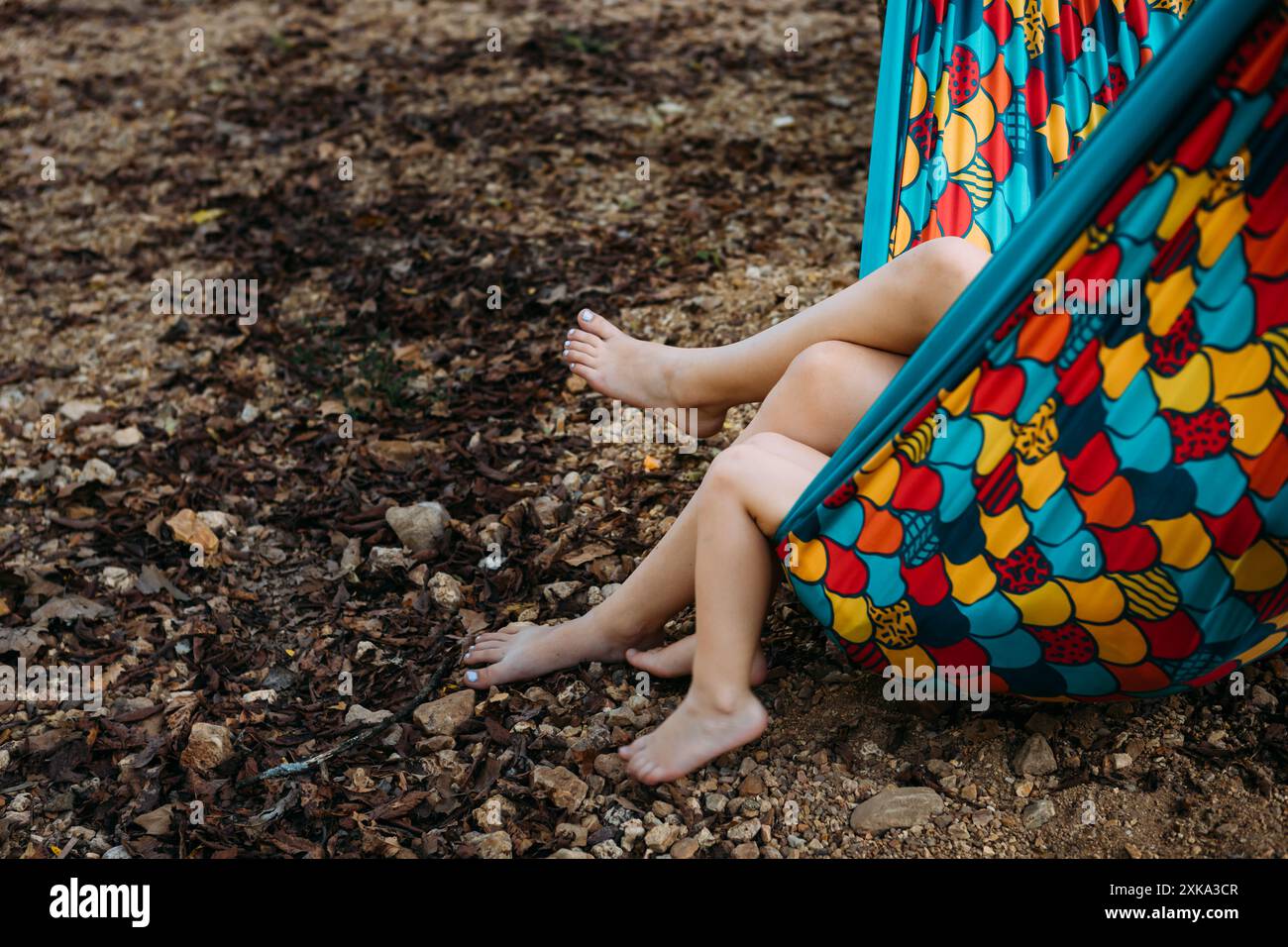 Kids legs hanging out of colorful hammock at camp Stock Photo - Alamy