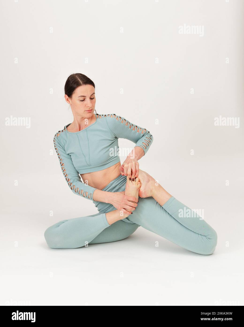 Young woman practicing asana on white background studio Stock Photo - Alamy