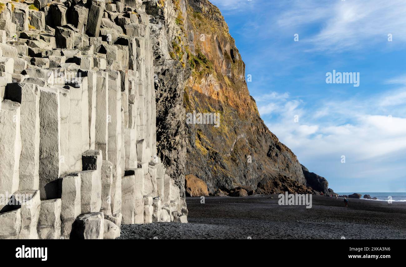 Gardar basalt columns on Reynisfjara Black Sand Beach, Iceland. A rocky cliff with a gray and ...