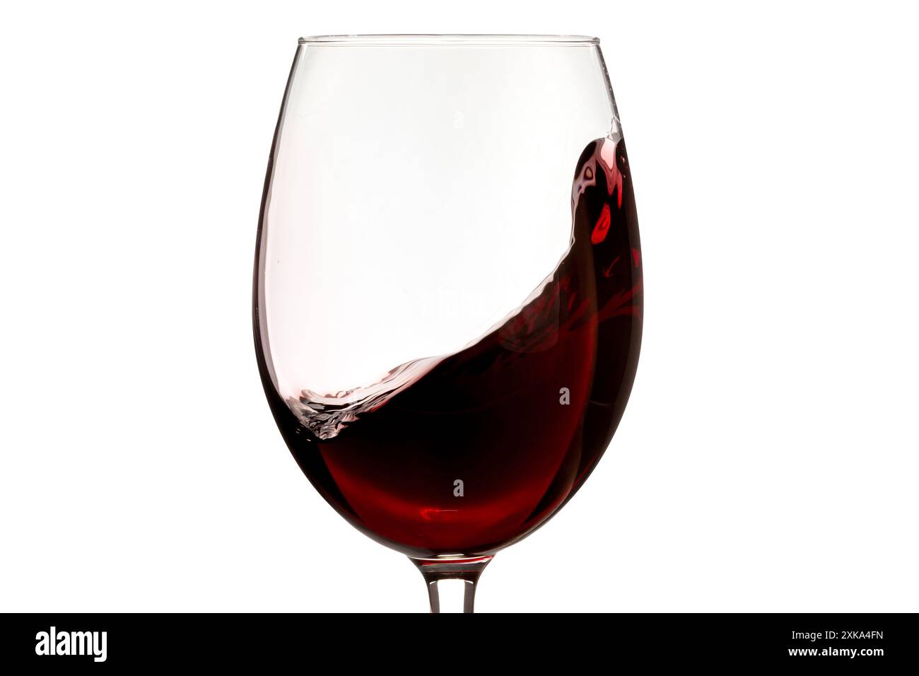 Glass of red wine with the wine forming a wave Stock Photo - Alamy