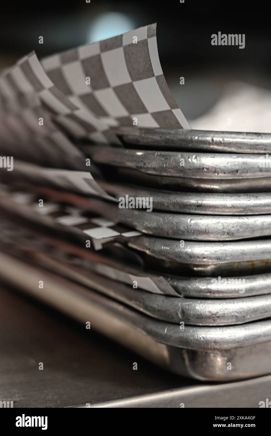 Stack of serving trays with black and white checkered liner paper Stock ...