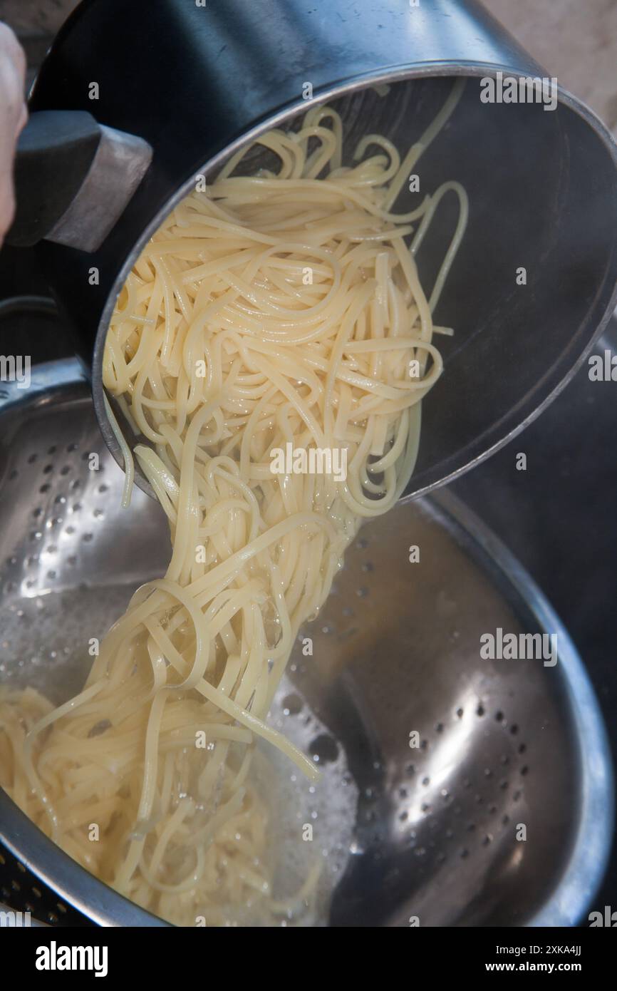 Tagliatelle being home cooked and poured from boiling to be strained ...