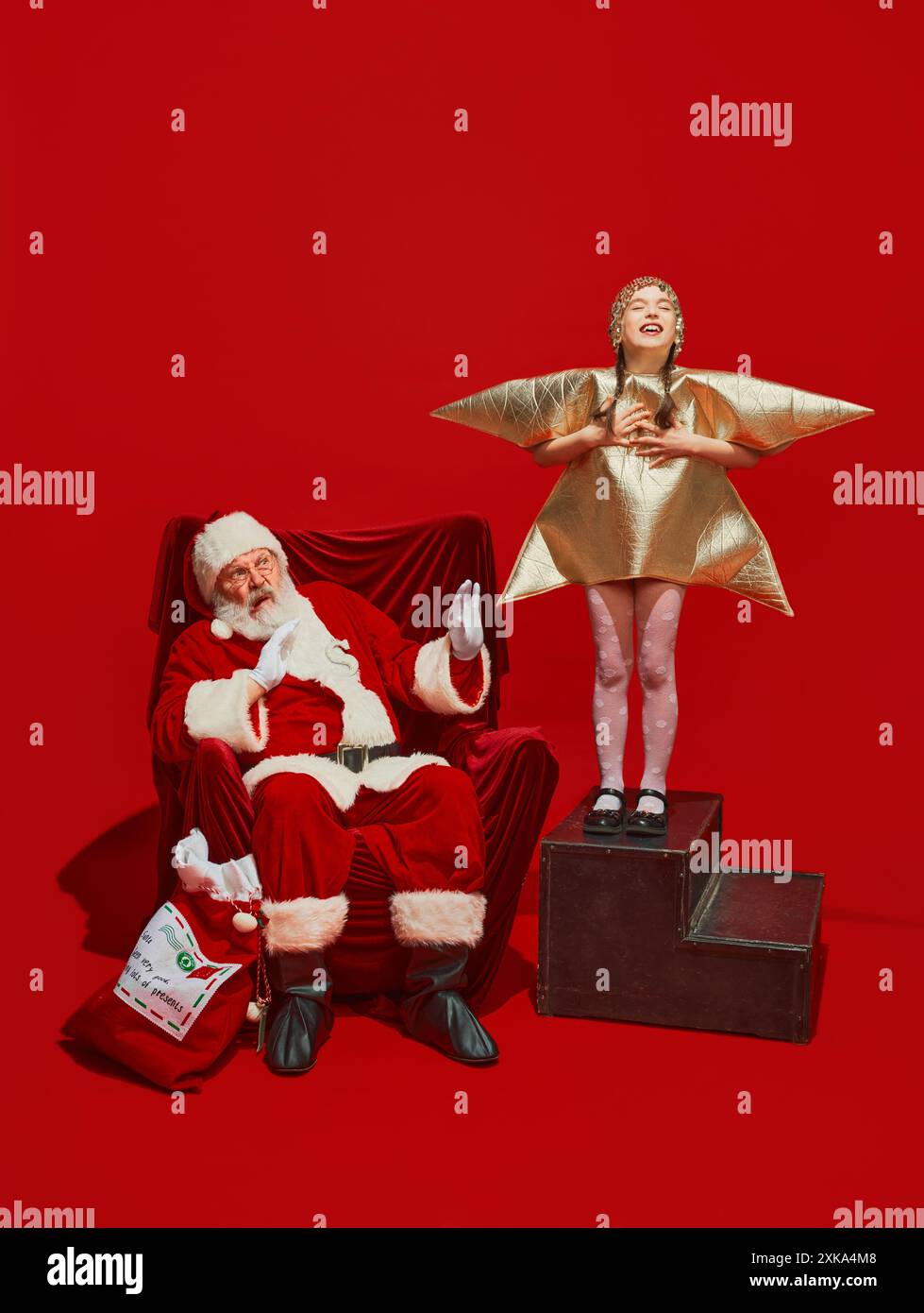 Little girl in star shape costume singing for displeased emotive Santa ...