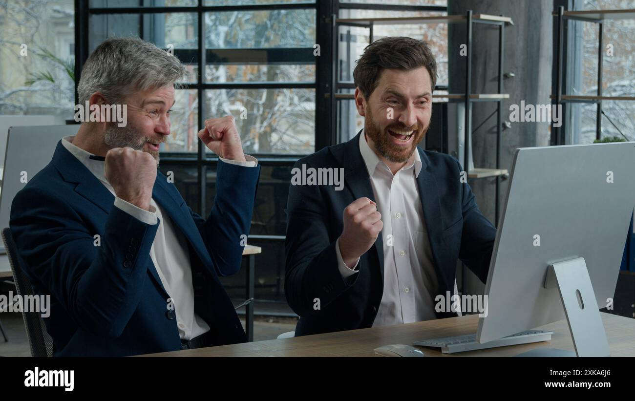 Two surprised happy Caucasian businessmen men business partner ...
