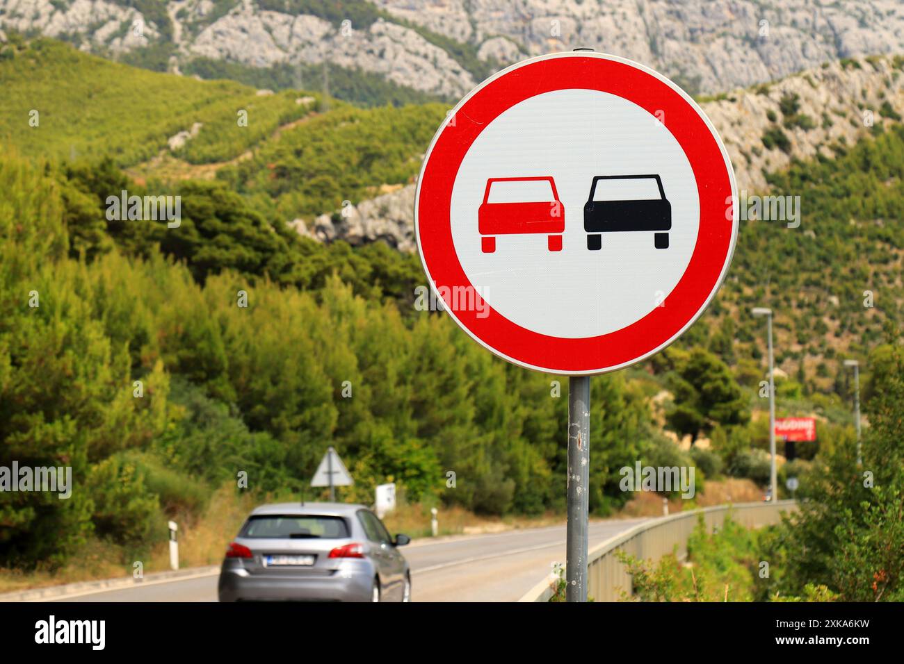 Sign - overtaking is prohibited on the side of a beautiful mountain ...