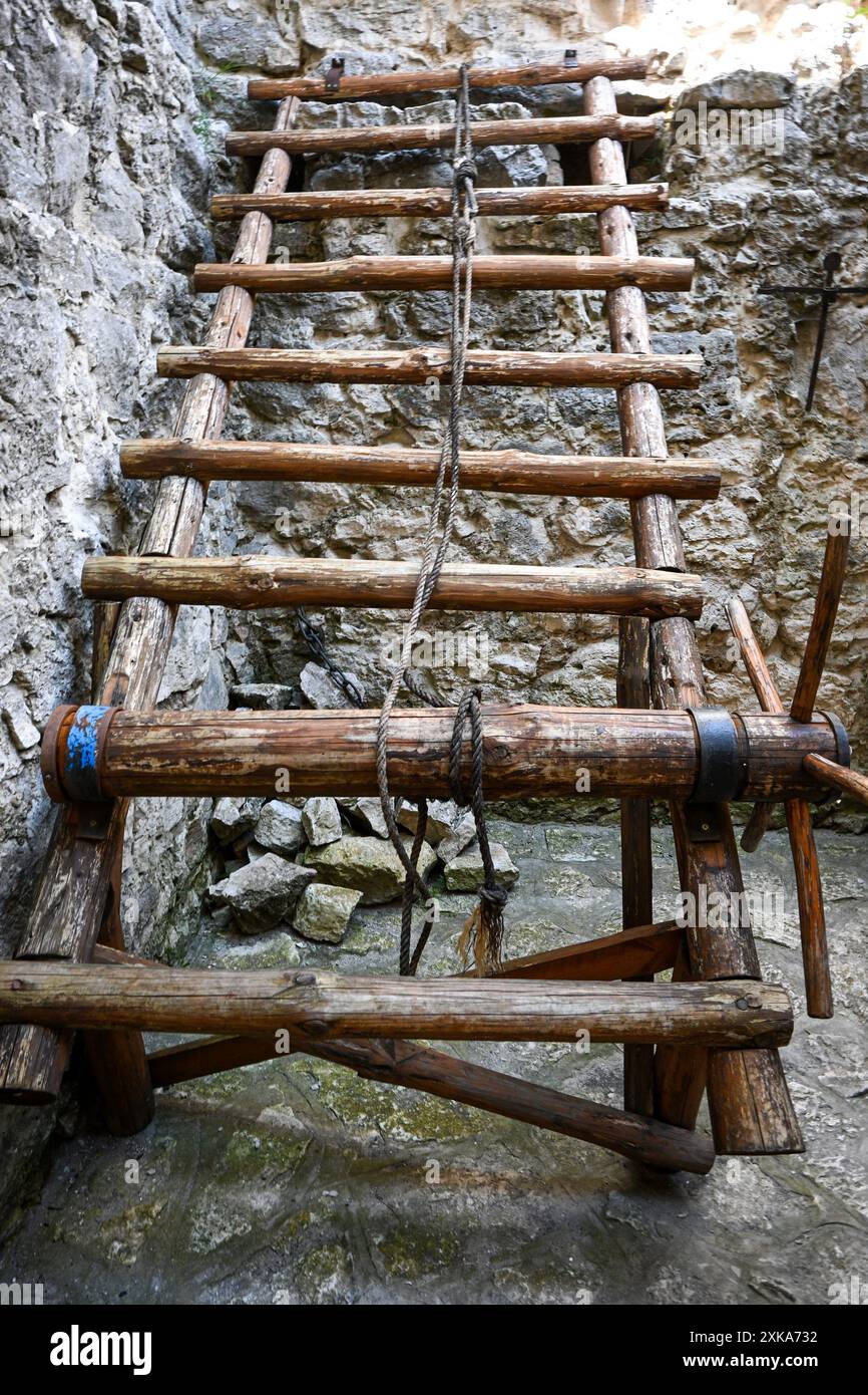 Old wooden medieval siege ladder with ropes and metal parts is leaning ...