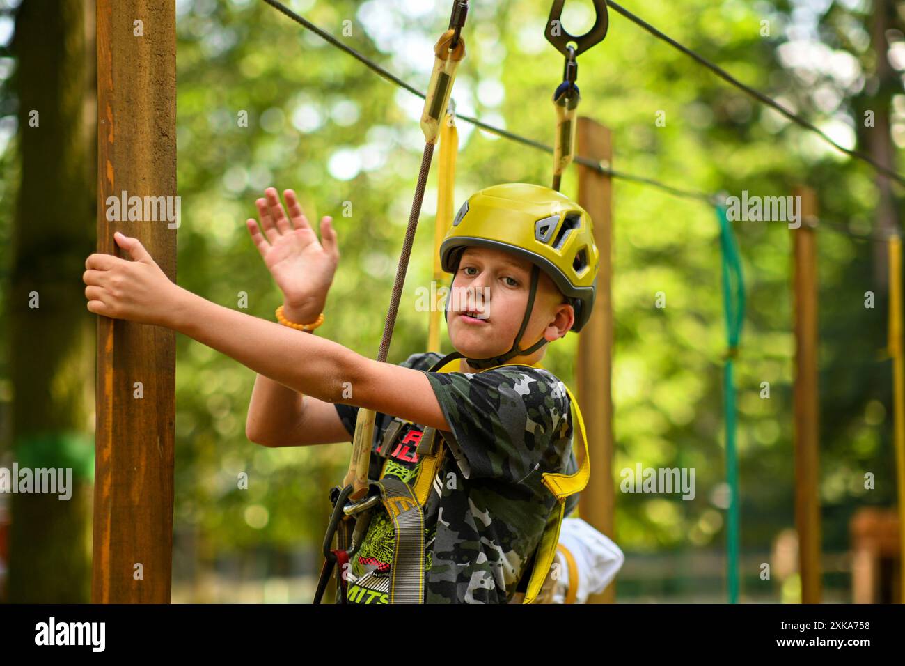 Young adventurer navigating a treetop obstacle course, demonstrating ...