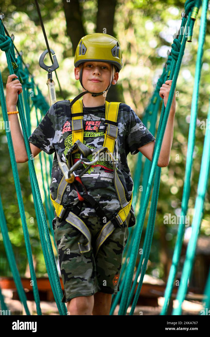 Young adventurer navigating a treetop obstacle course, demonstrating ...