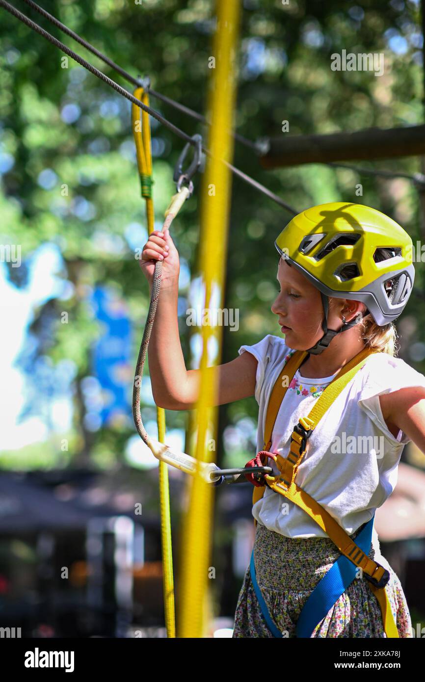 Young adventurer navigating a treetop obstacle course, demonstrating ...