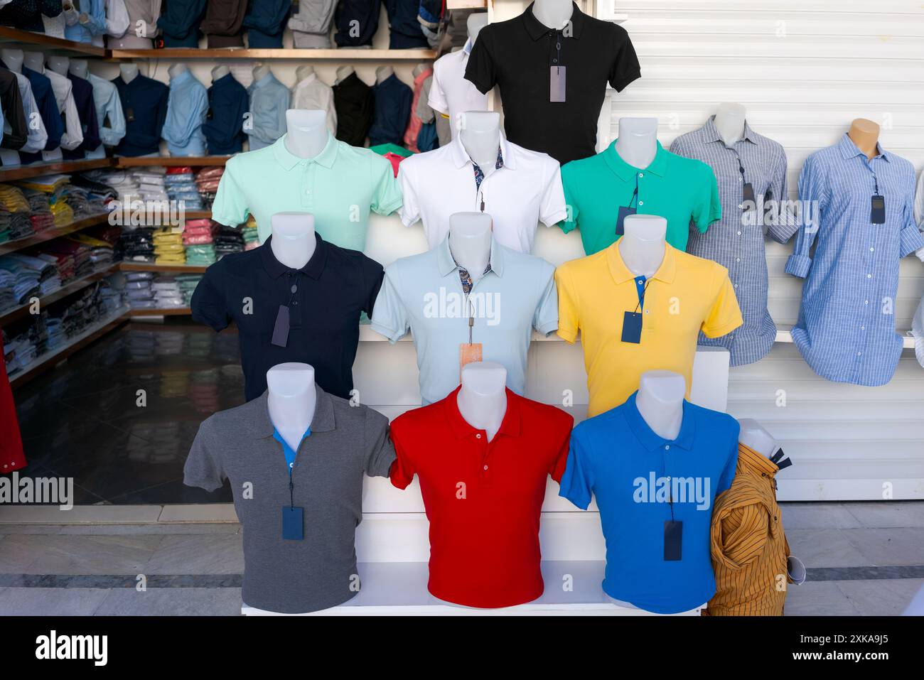 Colorful polo shirts on mannequins in a clothing store display, with ...