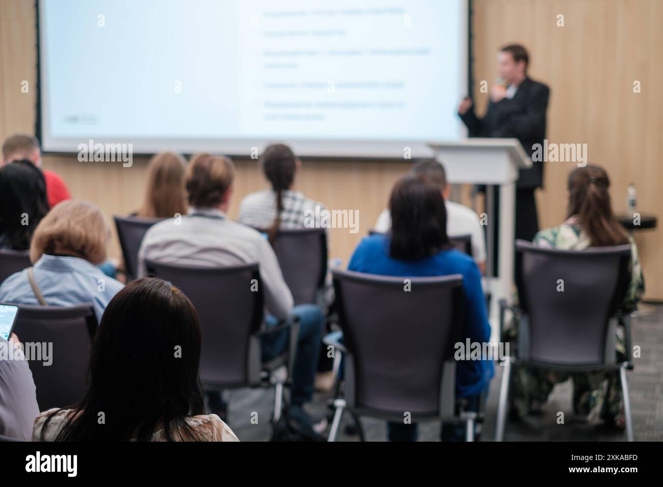 Business professional giving presentation to attentive audience in ...