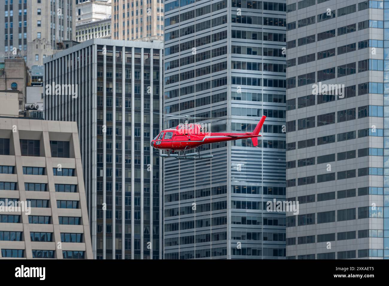New York, USA - A red helicopter threads its way through the high rise ...