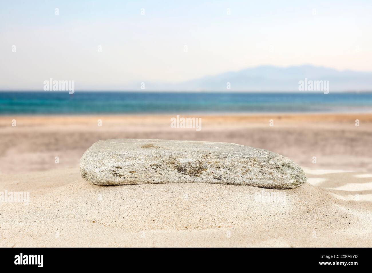 Flat marble stone on sand on the beach with copy space for products ...