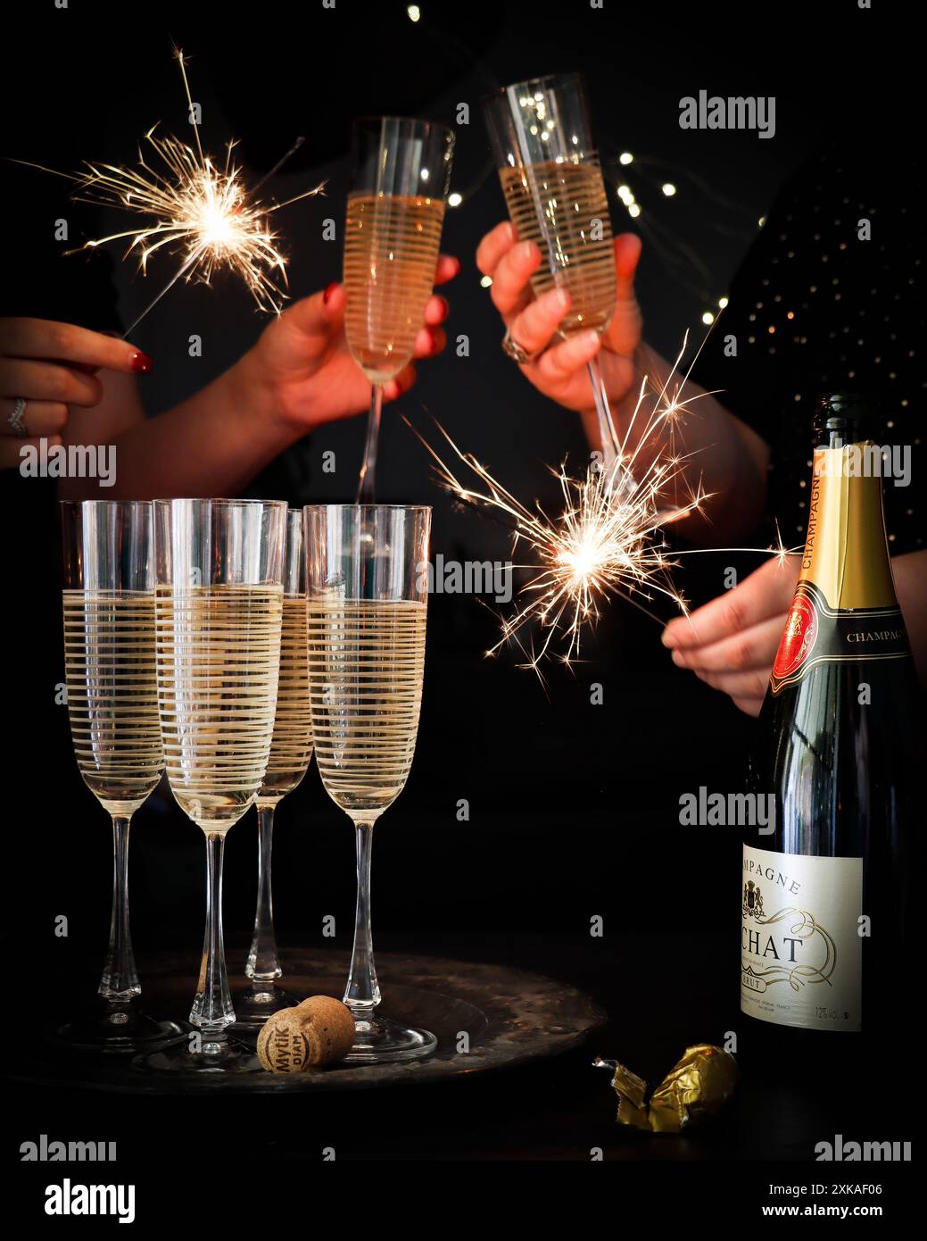 celebratory scene with hands holding sparklers and champagne flutes ...