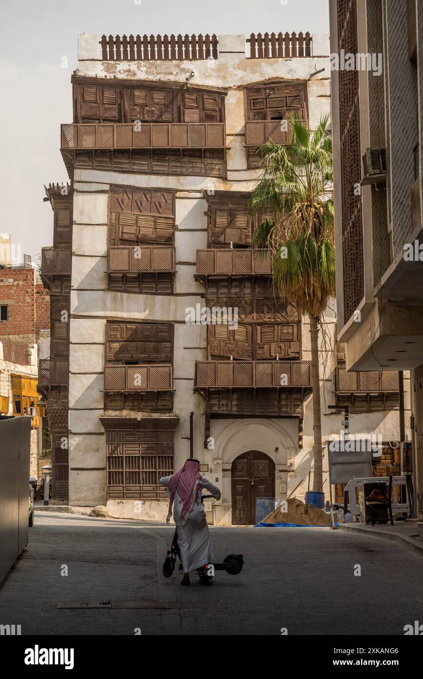 The Arab man on the scooter at the streets of Jeddah Al-Balad district ...