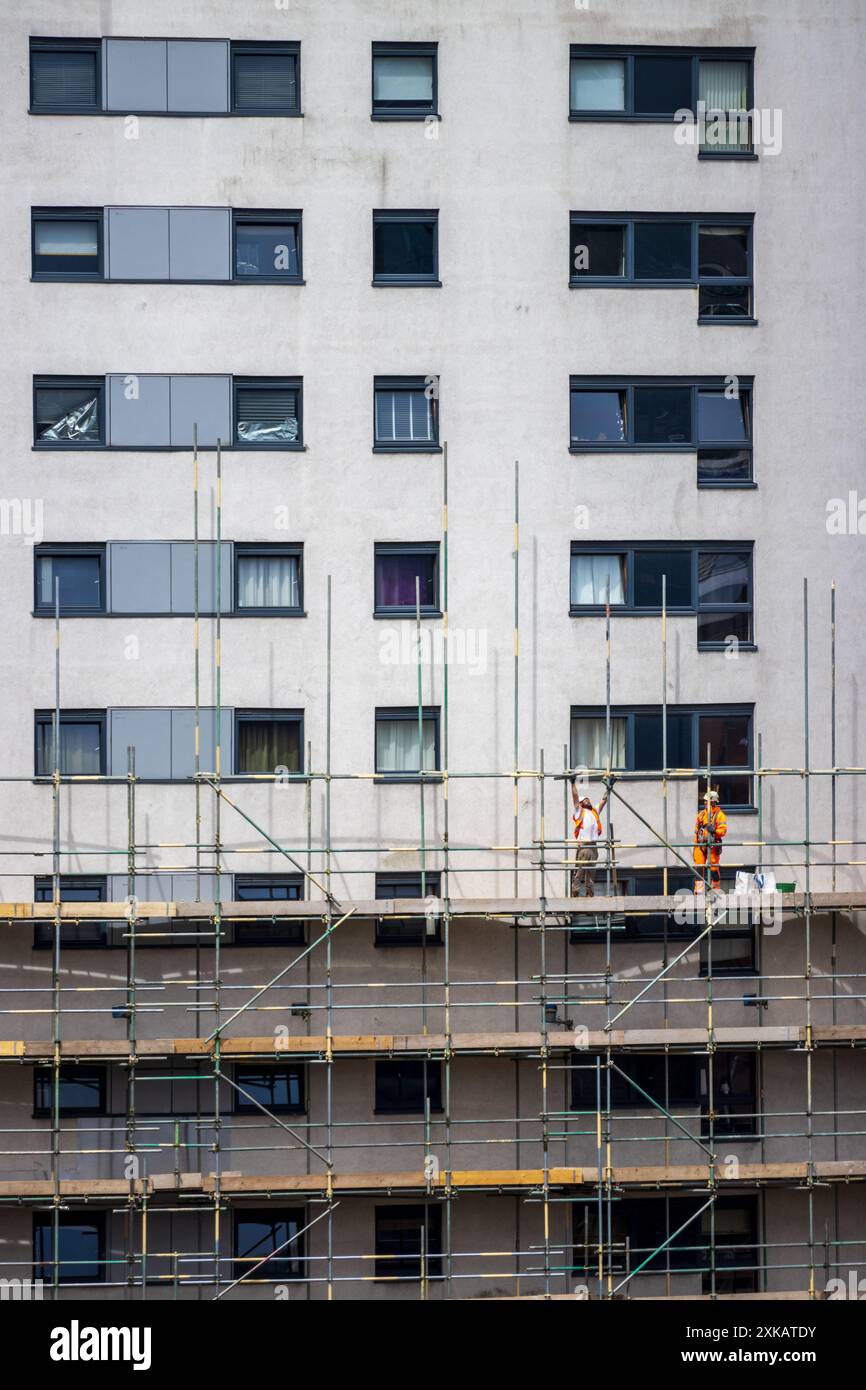 Two workmen constructing scaffolding on the outside of Magellan House ...