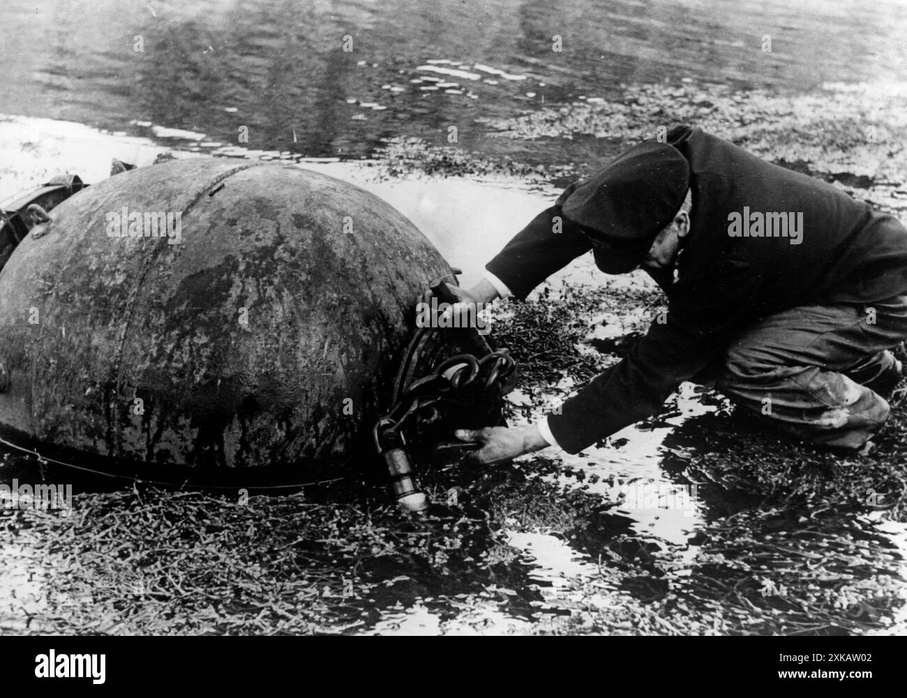 German soldier defusing a sea mine washed up on the beach on the ...