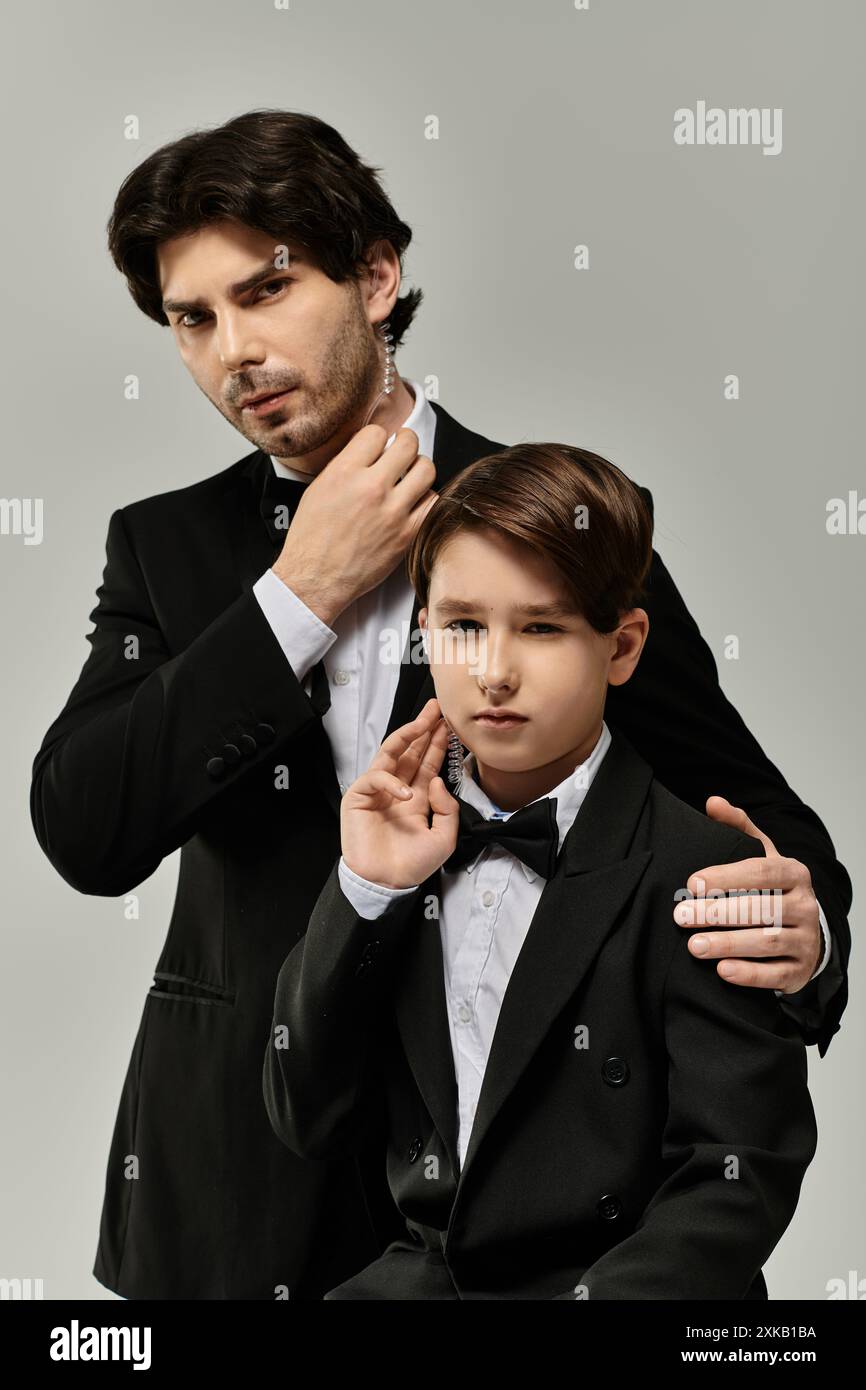 A father and son, both dressed in formal attire, stand side by side ...