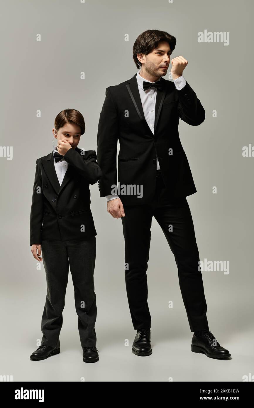 A father and son stand side-by-side, both dressed in black suits Stock ...