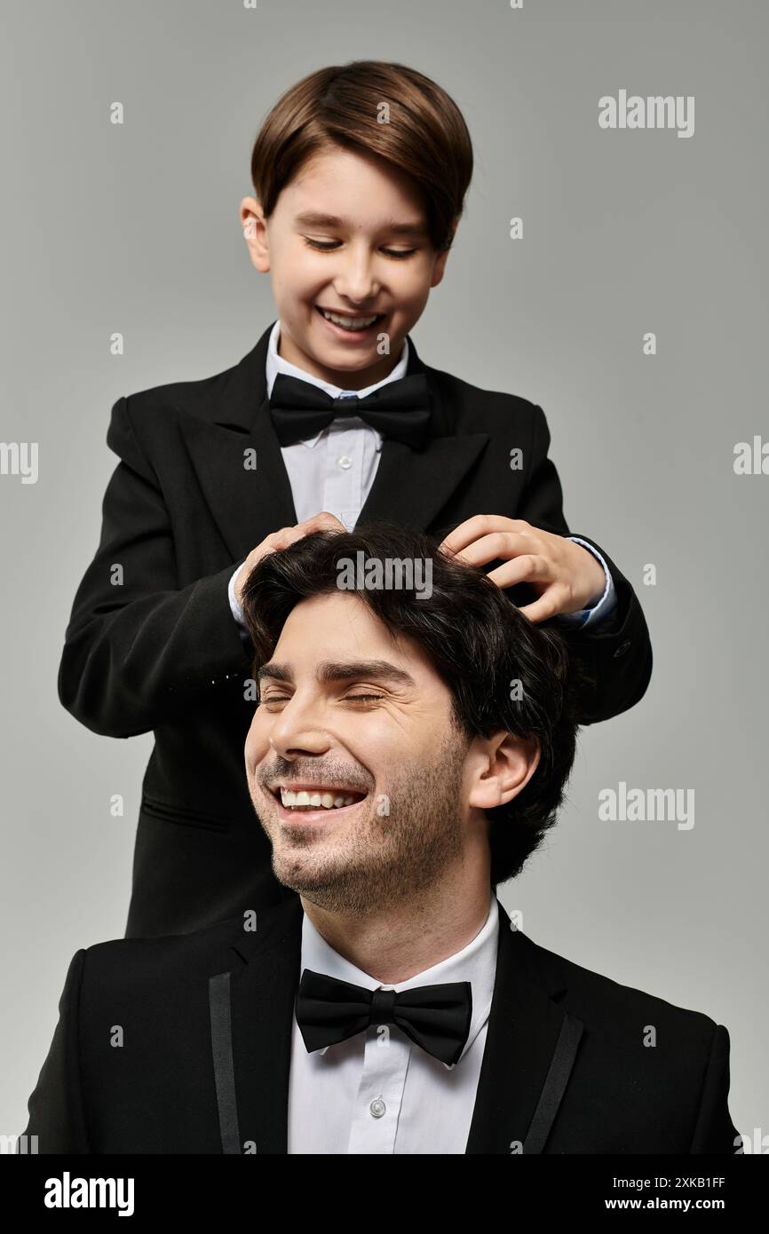 A father smiles contentedly as his son playfully ruffles his hair Stock ...