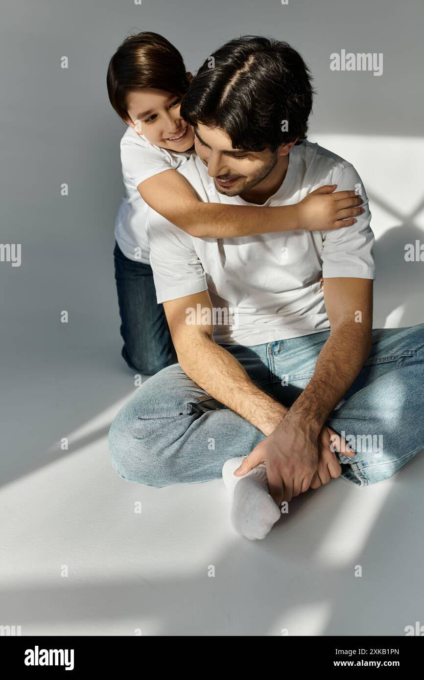 A father and his son share a heartwarming hug while sitting on the ...