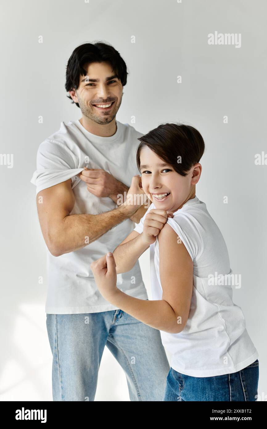 A father and son playfully flex their muscles, sharing a lighthearted ...