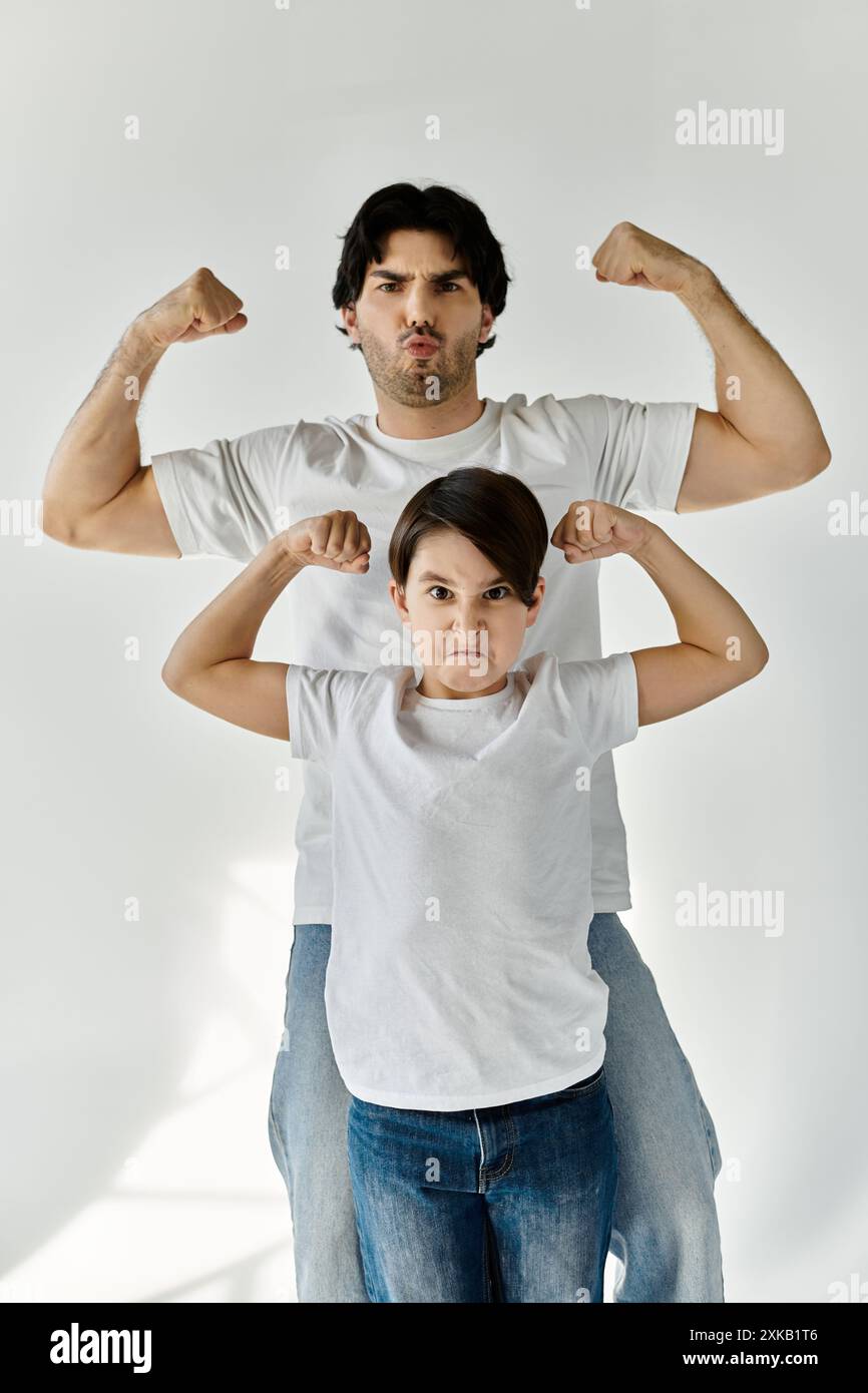A father and son stand side-by-side flexing their muscles in a playful gesture Stock Photo - Alamy