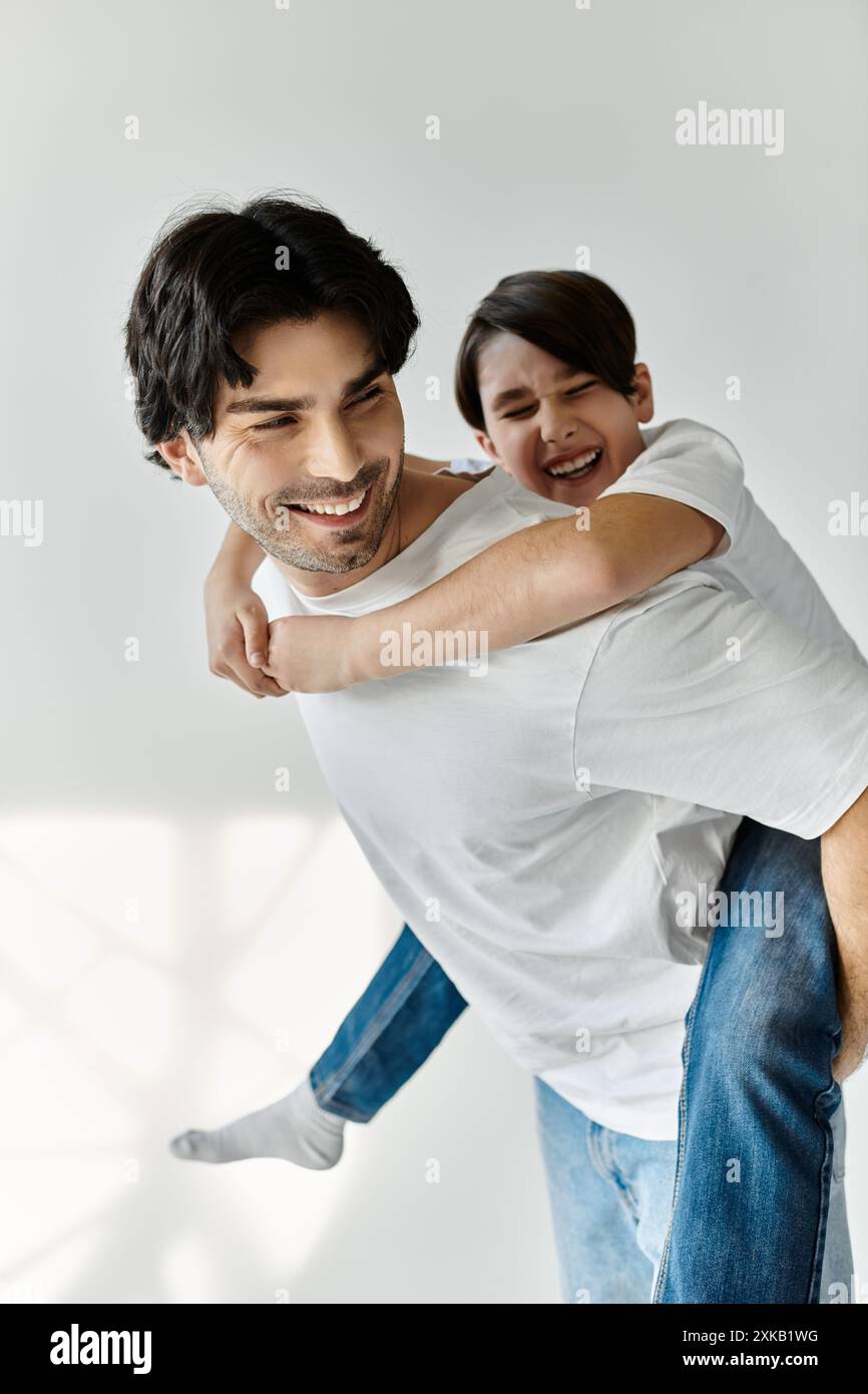 A father gives his son a piggyback ride, both laughing joyfully Stock ...