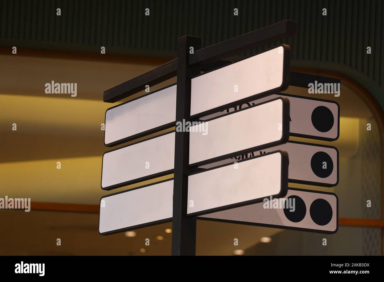 Blank signpost hanging on pole on shopping mall background Stock Photo ...