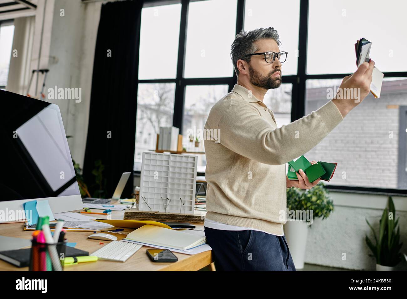 A handsome businessman with a beard stands in a modern office ...