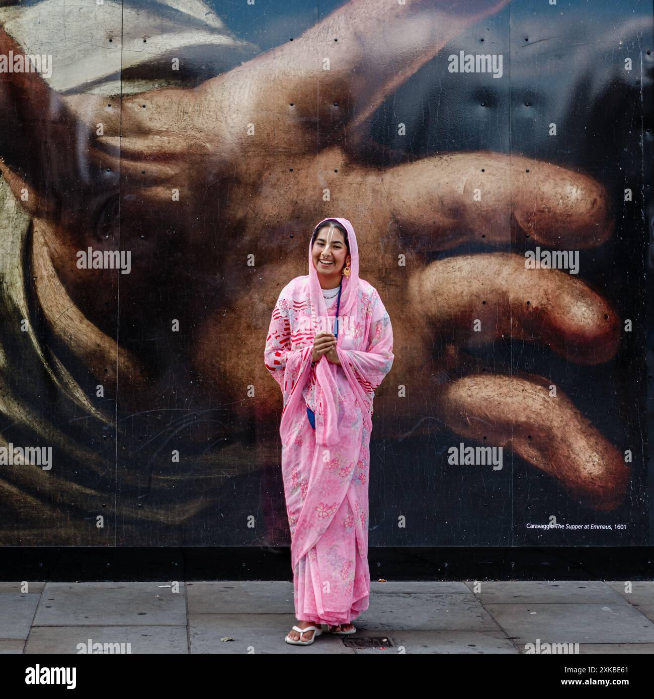 A monk in a saree at the Hare Krishna event poses in front of ...