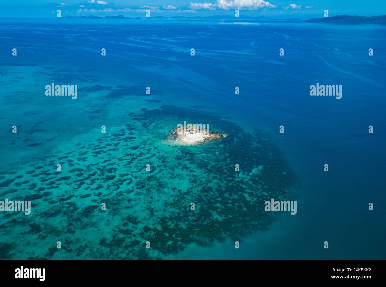 Aerial view of a small tropical island on an atoll with beautiful sandy ...
