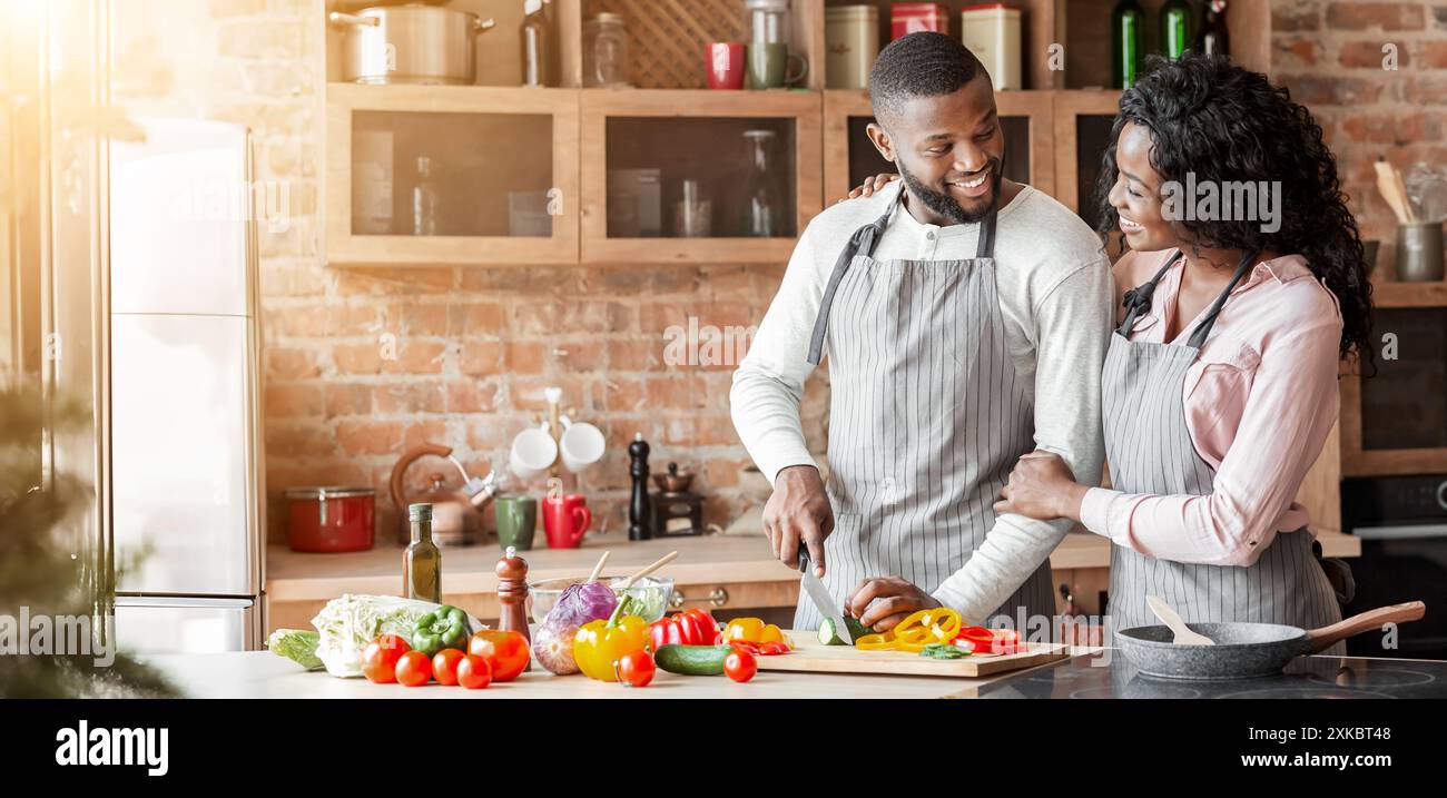 Emotional african couple cooking dinner together in kitchen Stock Photo ...