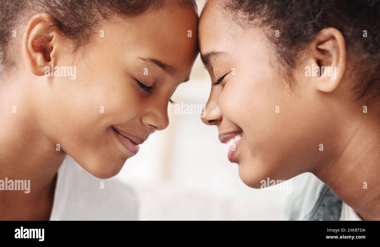 Two girls with eyes closed touching each other with foreheads Stock ...