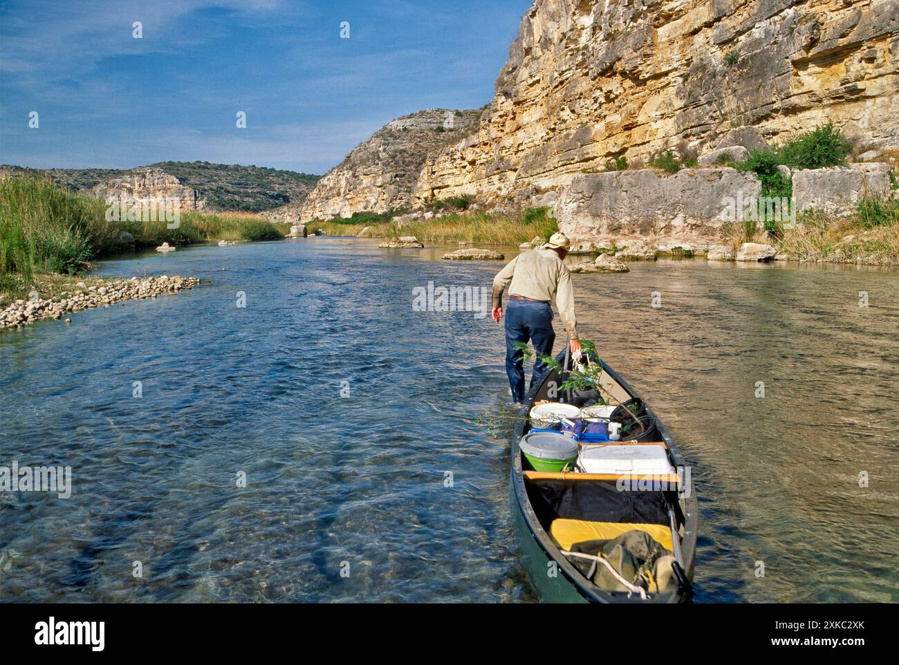 Man pulling canoe through shallow section of Pecos River near Oso ...