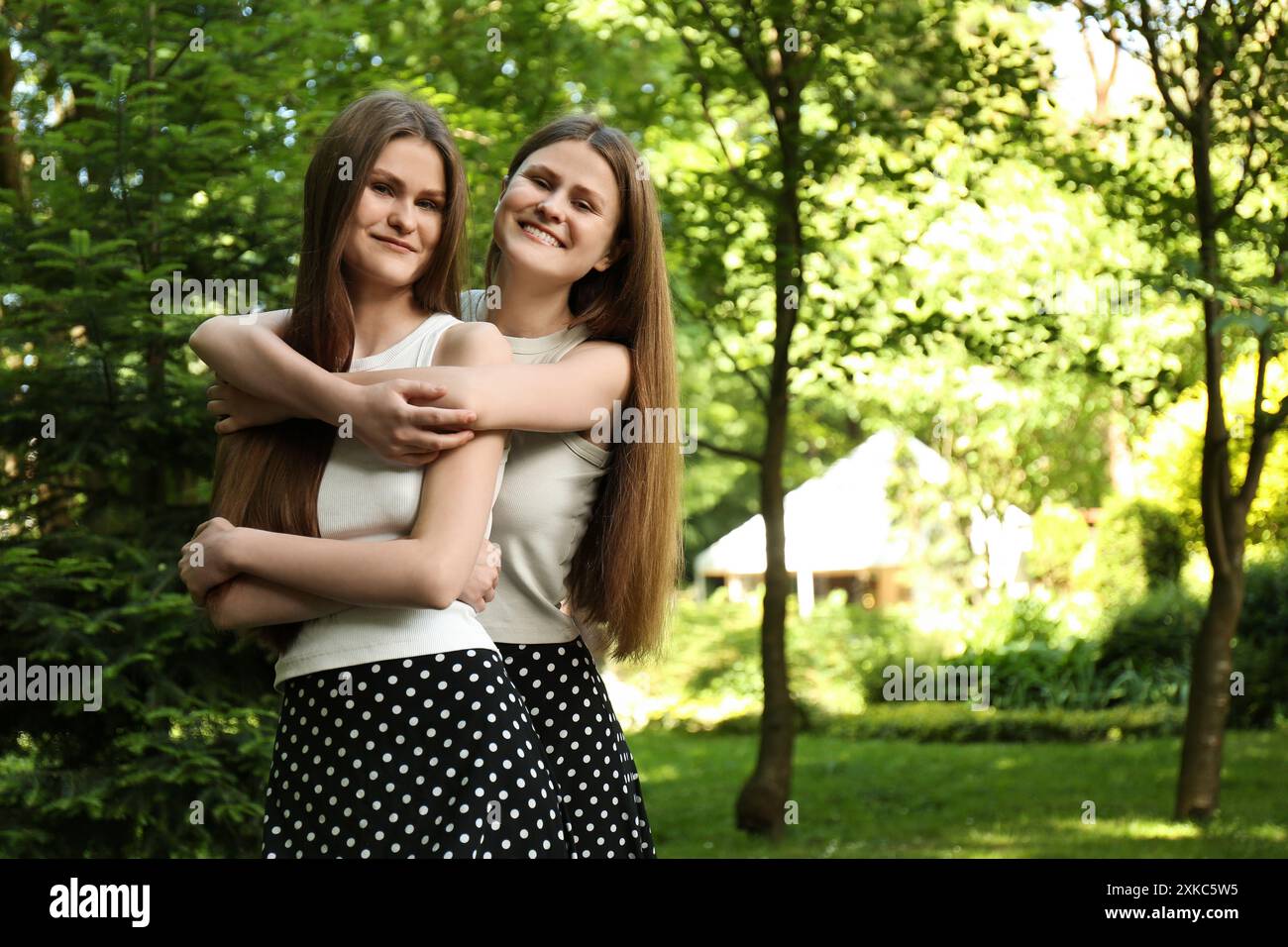 Portrait of two beautiful twin sisters in park Stock Photo - Alamy