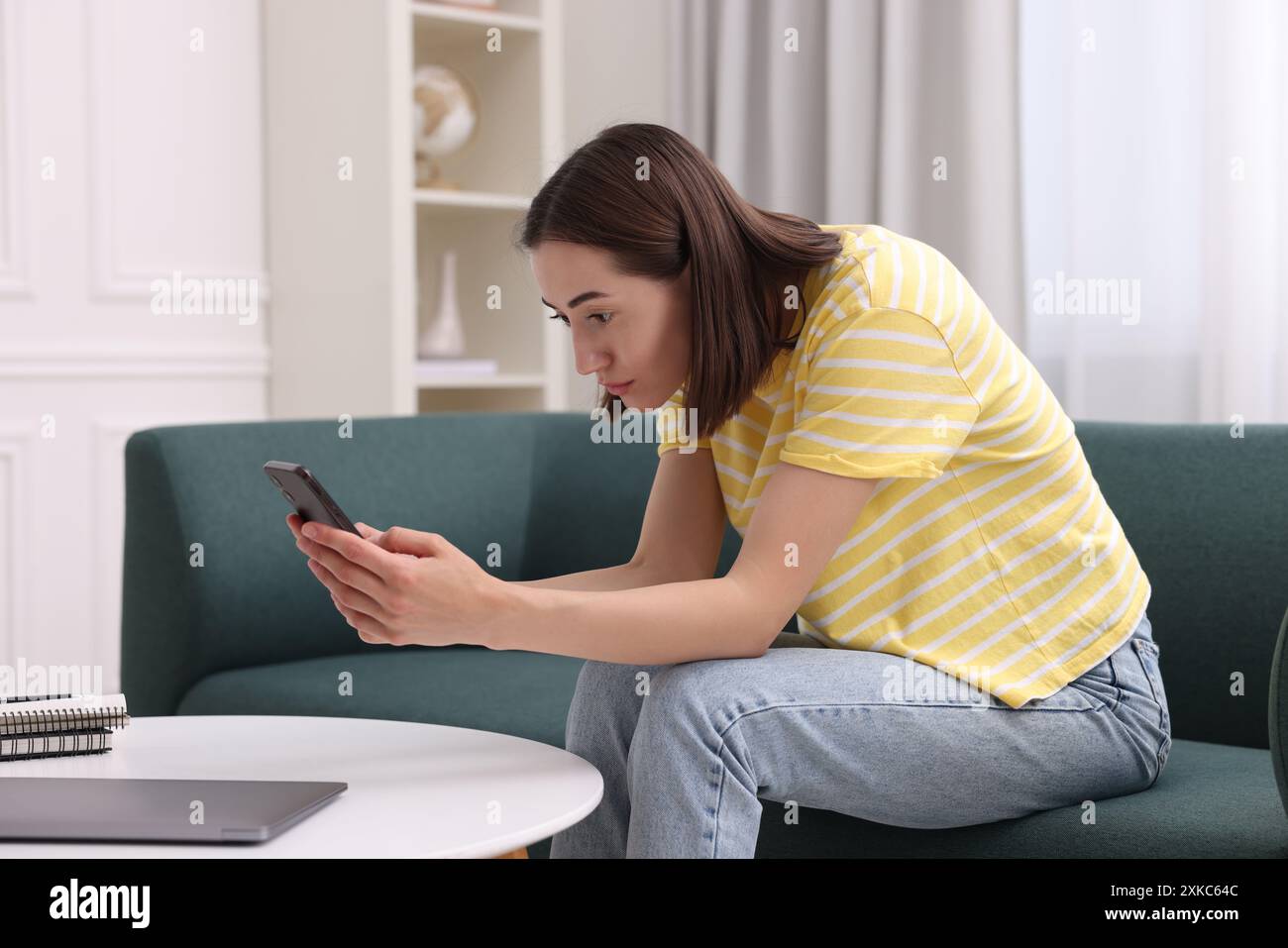 Woman with poor posture using smartphone at home Stock Photo - Alamy