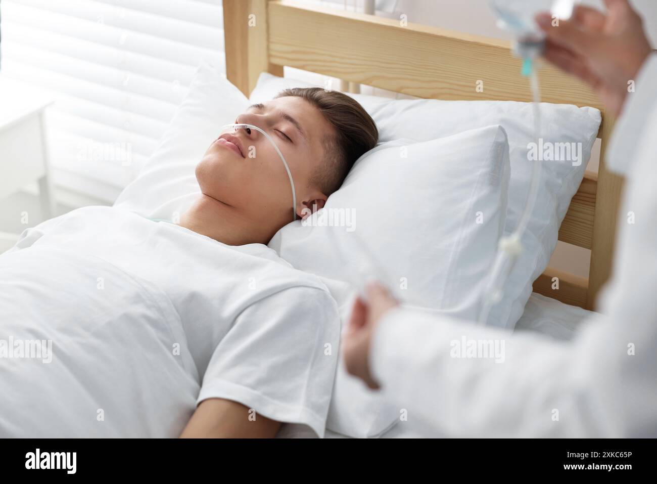 Coma patient. Doctor near unconscious young man in hospital, closeup ...