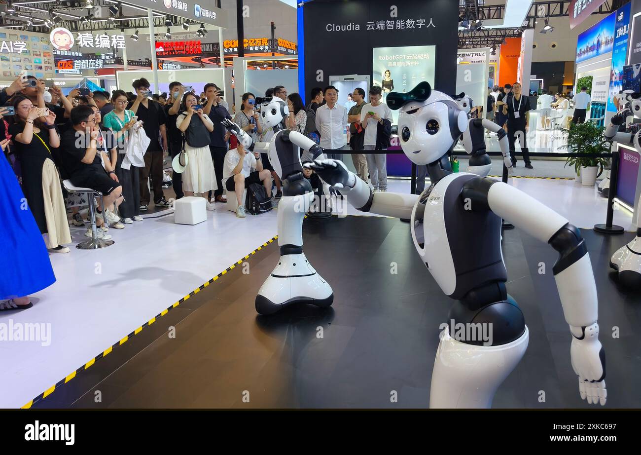Beijing, China. 5th July, 2024. Visitors take photos of dancing robots ...