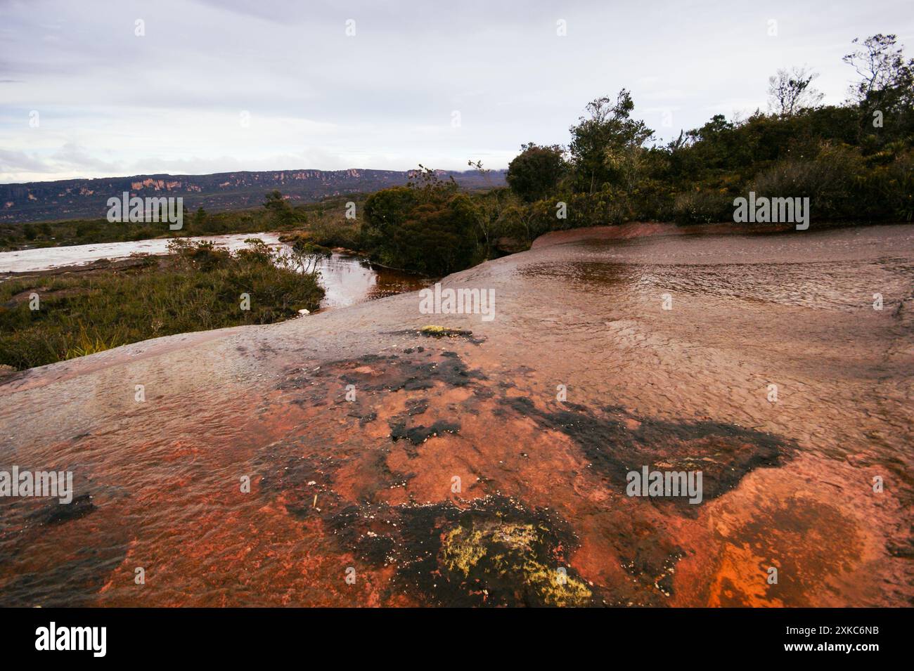 Shallow freshwater river running over red sandstone on the plateau of ...