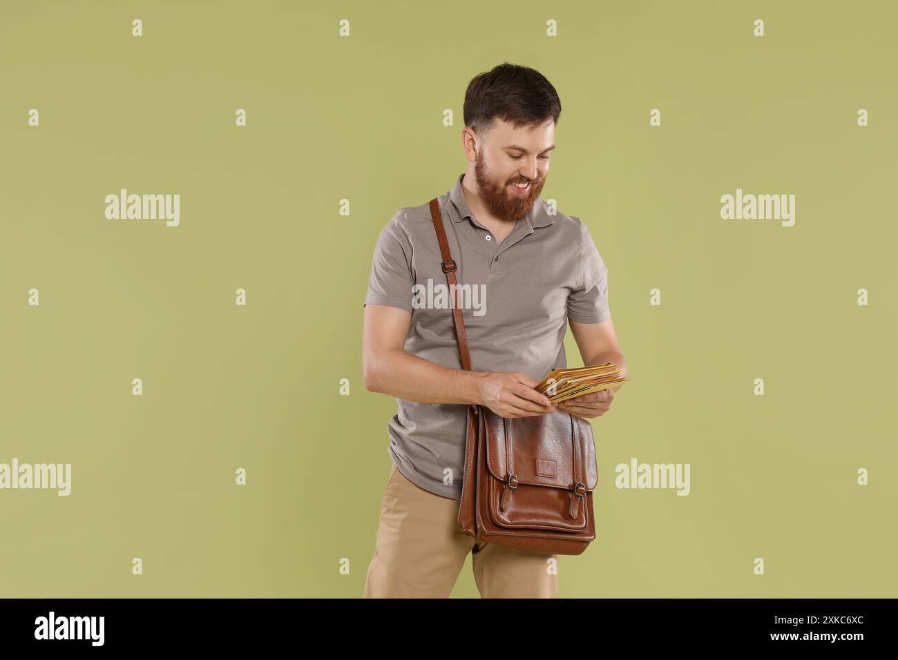 Postman with brown bag delivering letters on light green background ...