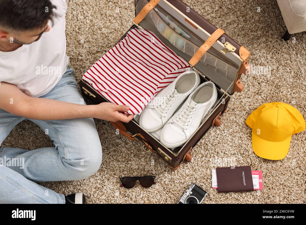 Man packing suitcase on floor at home, top view Stock Photo - Alamy