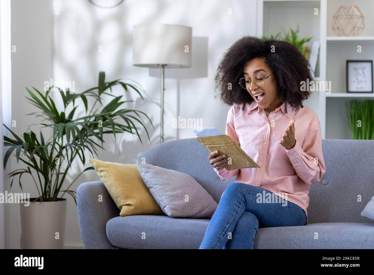 Happy woman receiving exciting news from letter while sitting ...