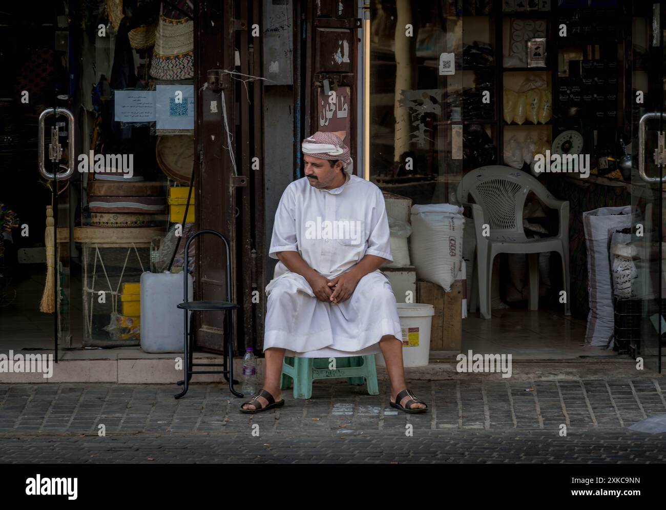 The owner of the local shop waiting for customers at the street of ...